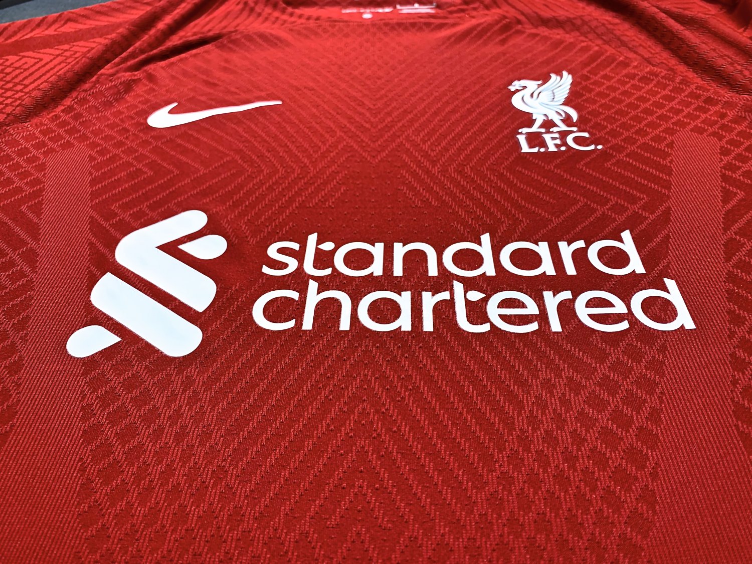 Liverpool Home football shirt 2022 - 2023. Sponsored by Standard Chartered
